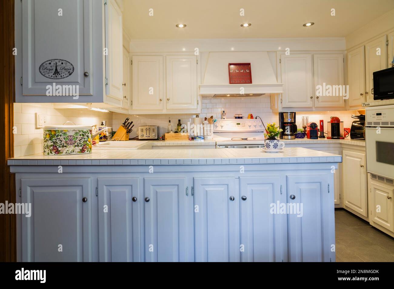 Country style kitchen with white cabinets and ceramic tile countertop ...
