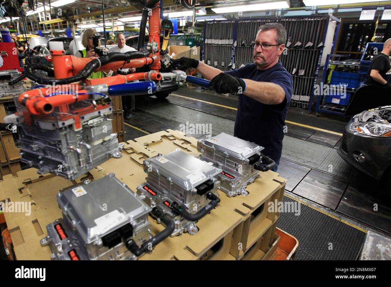 Assemblyman Mark Lynett lifts an inverter system converter for a hybrid ...