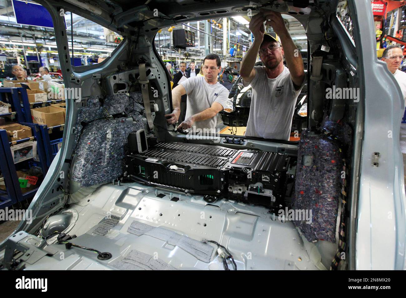 Ford assemblymen install the main battery on a C-Max hybrid vehicle at ...