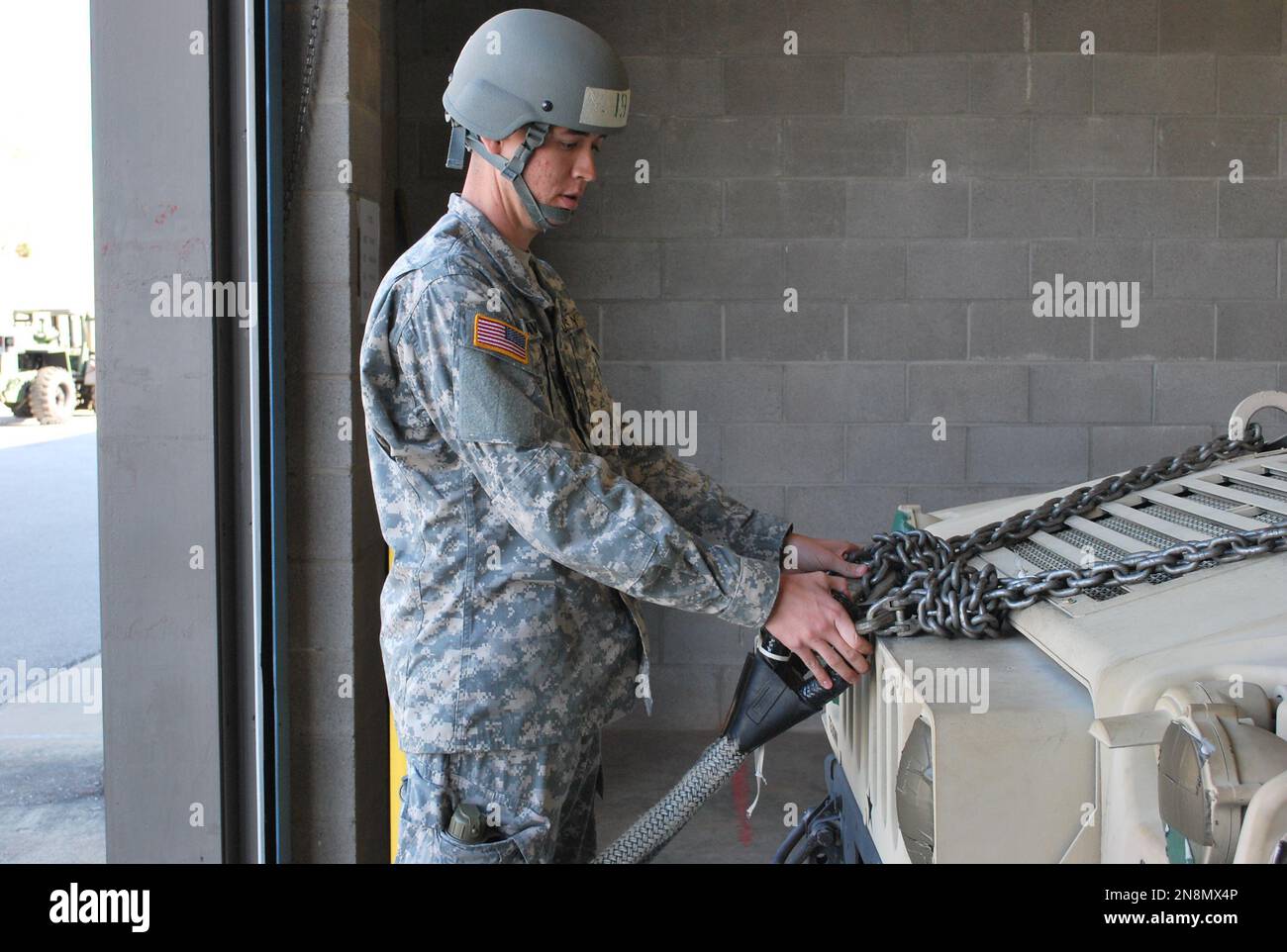 United States Army Pfc. Michael Savoldy checks the chains attached to a ...