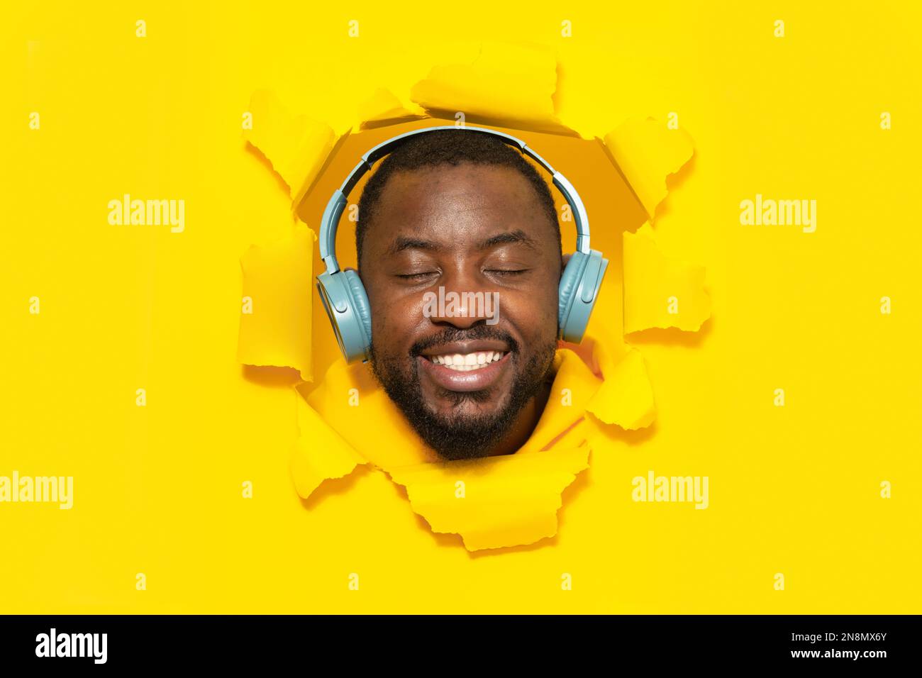 Relaxed african american man enjoying music in headphones with closed ...