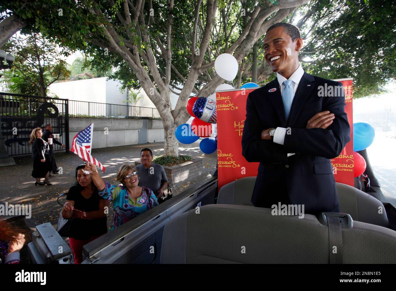 Pedestrians greet a wax figure of President Barack Obama from Madame ...