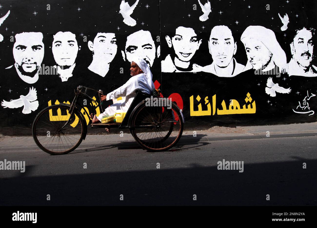 A Bahraini man rides past a mural in Barbar, Bahrain, on Wednesday, Nov ...