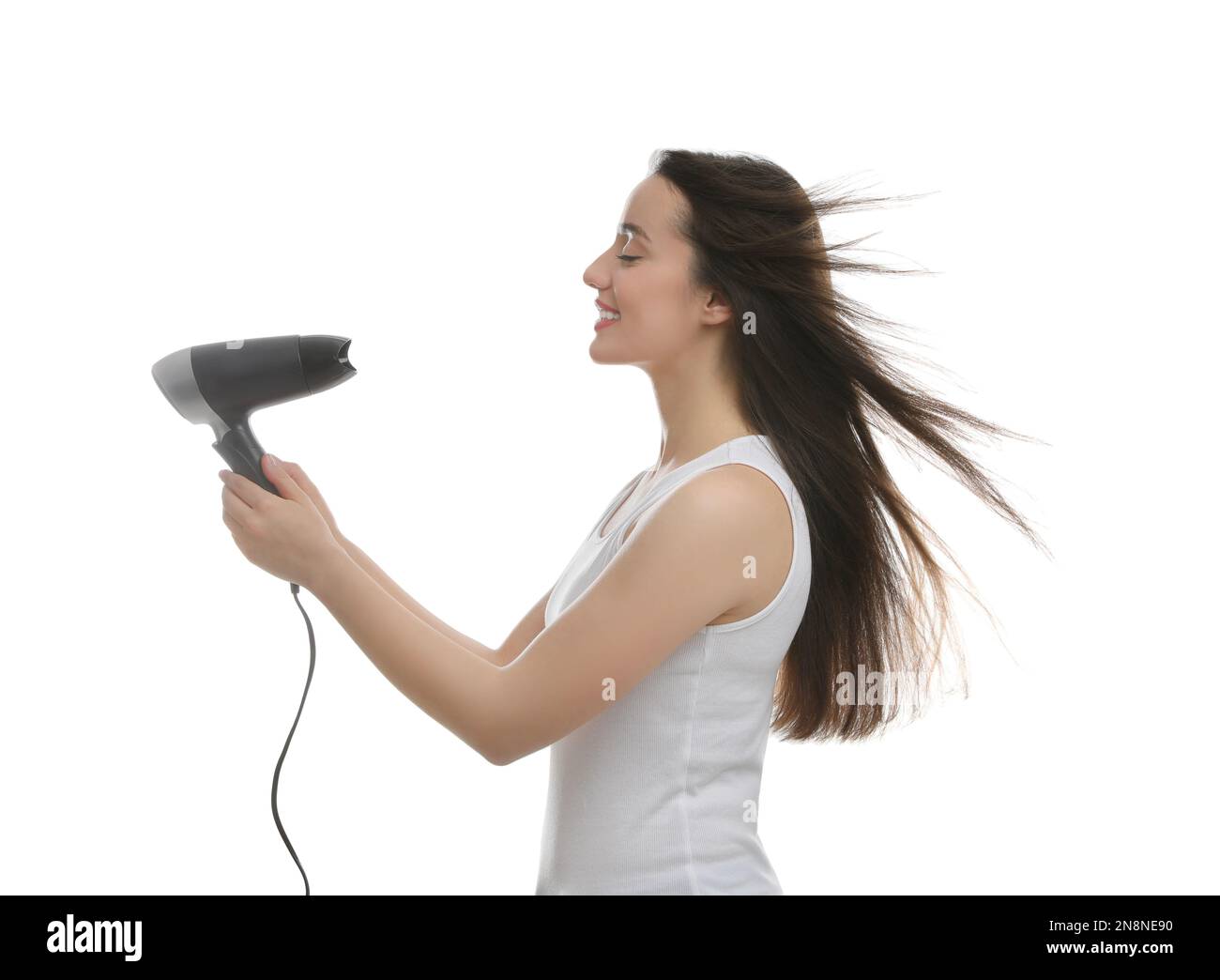 Beautiful young woman using hair dryer on white background Stock Photo ...