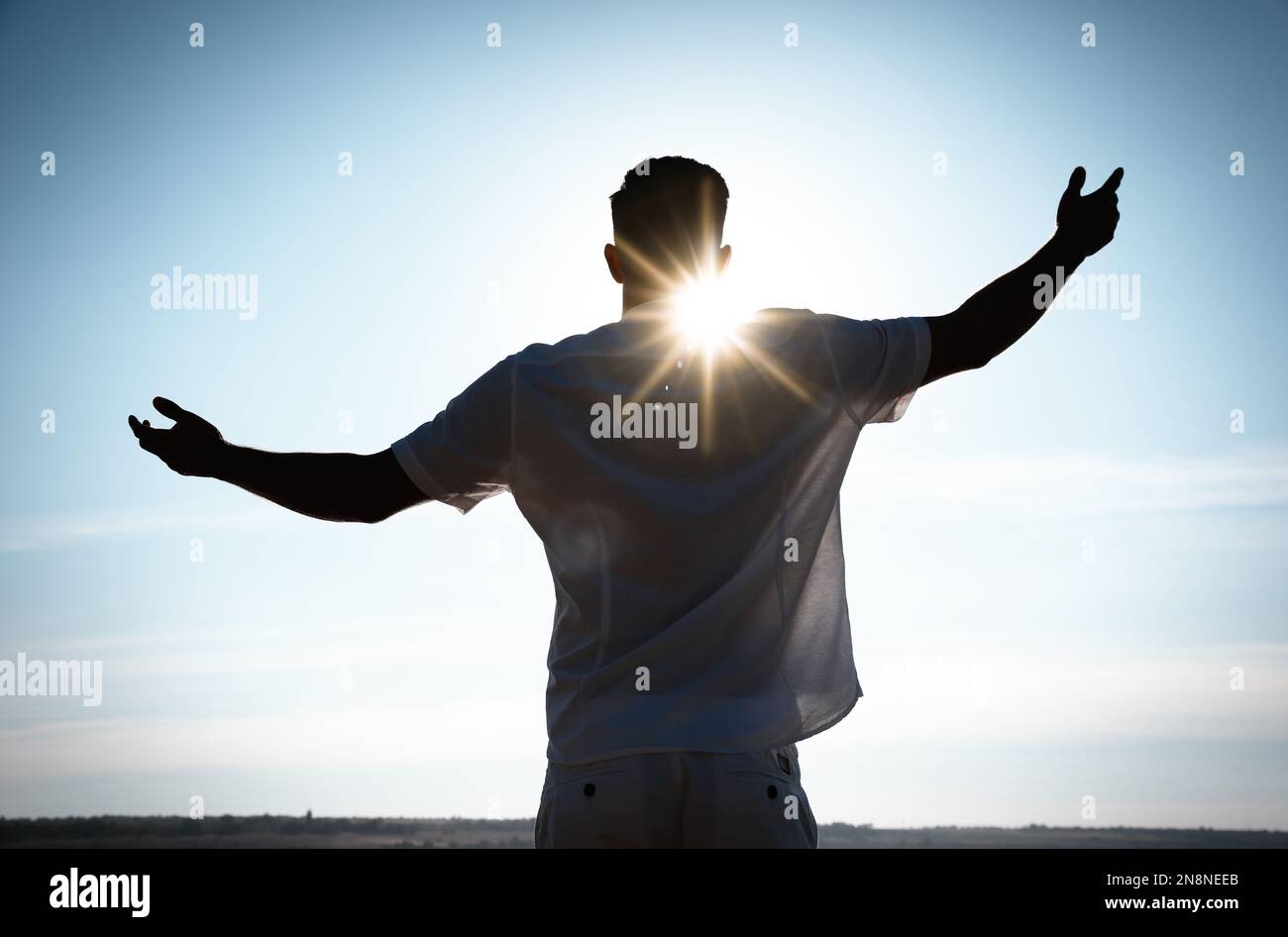 Man enjoying sunny day, back view. Nature healing power Stock Photo - Alamy