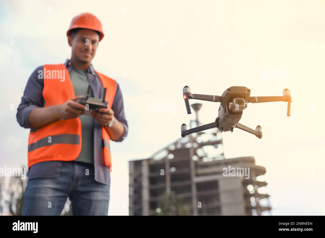 Builder operating drone with remote control at construction site ...