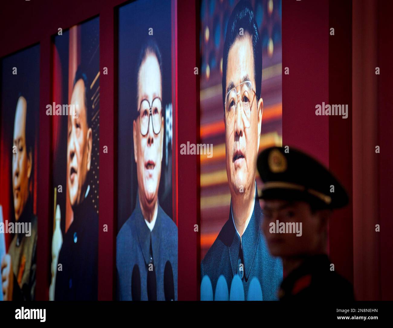 A Chinese paramilitary policeman stands guard next to a display showing ...