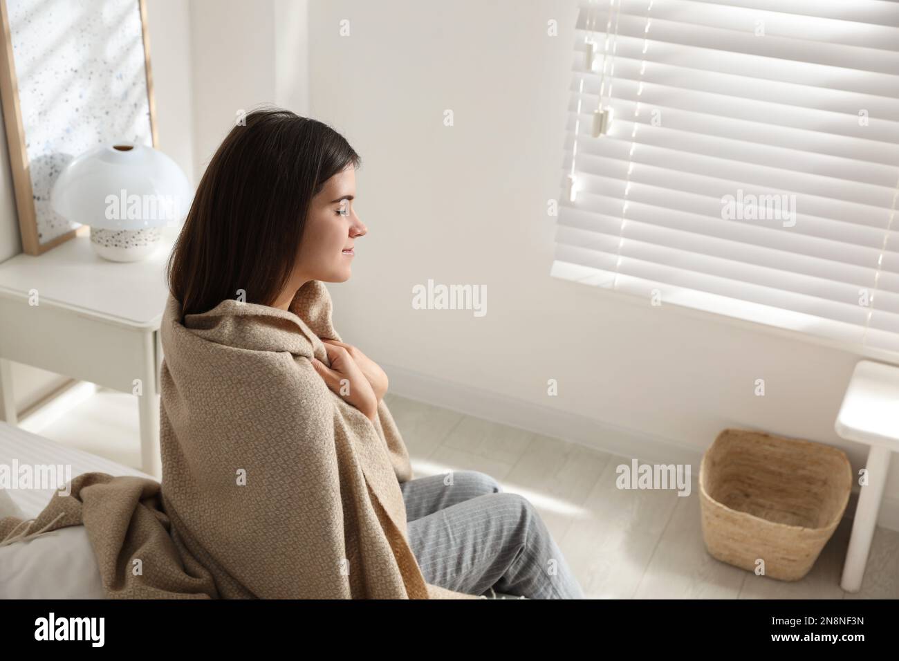 Woman covered with warm beige plaid indoors Stock Photo - Alamy