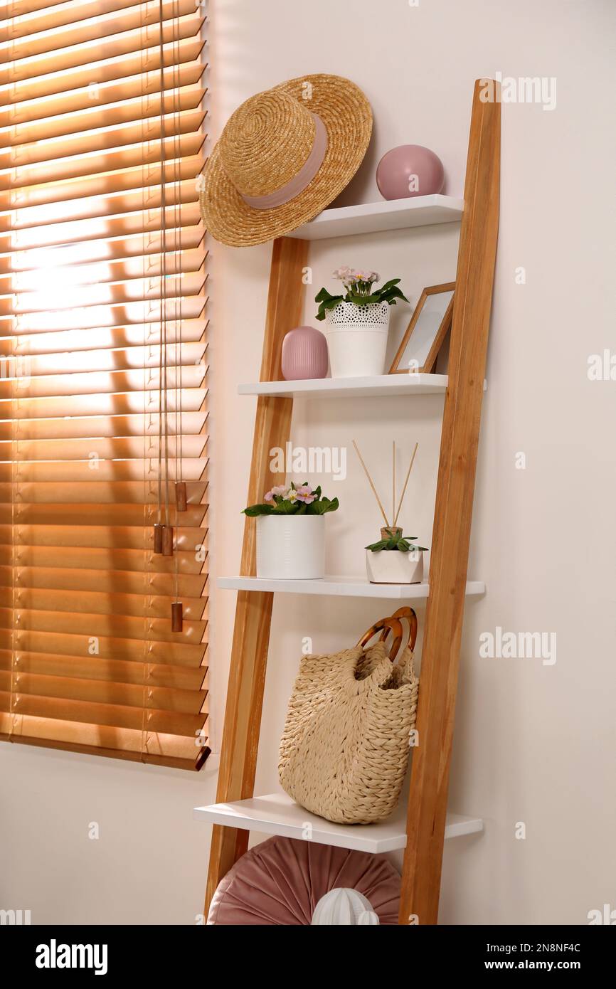 Stylish room interior with wooden ladder near white wall Stock Photo ...