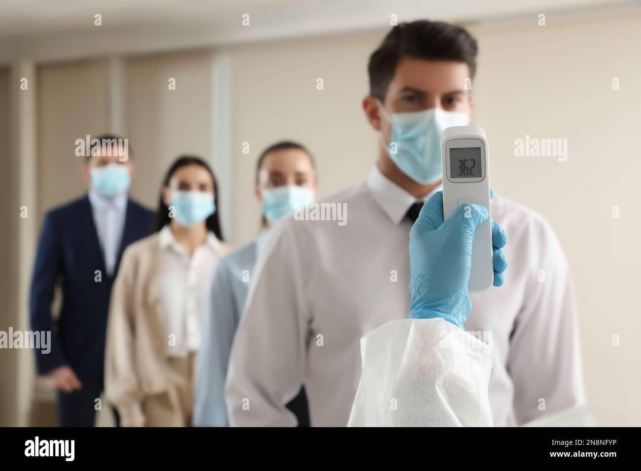 Doctor measuring employees temperature in office, closeup. Prevent ...