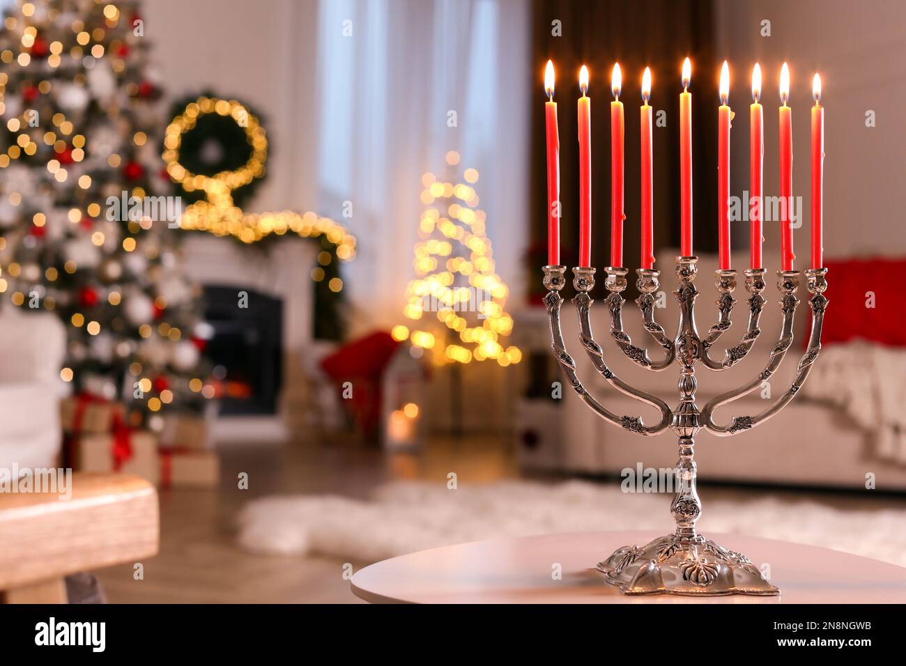 Silver menorah on white table in room with fireplace and Christmas ...