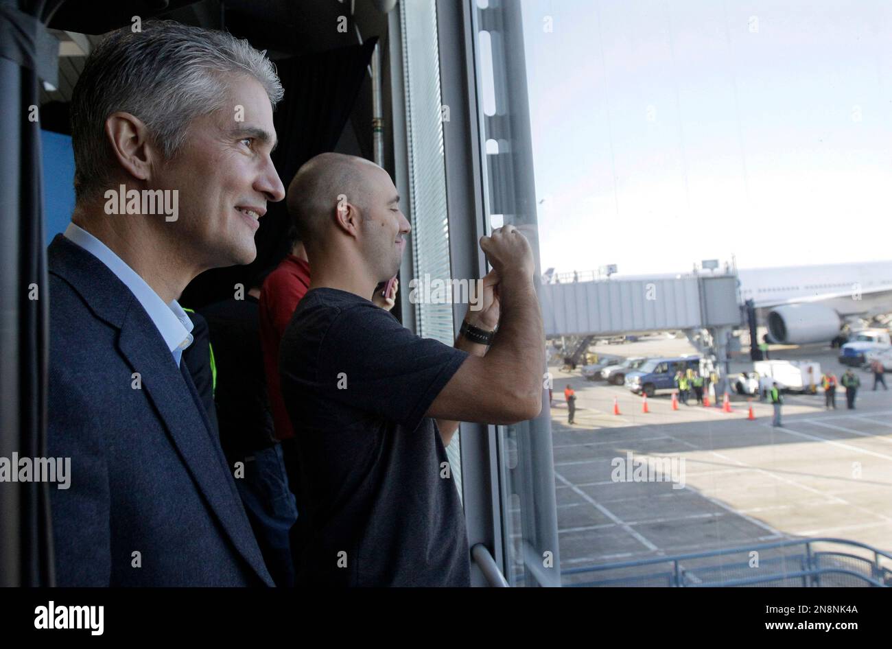 United CEO Jeff Smisek, left, looks outside after United's inaugural ...