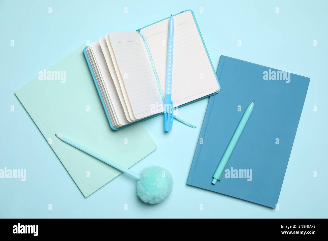 Pens and notebooks on light blue background, flat lay Stock Photo - Alamy