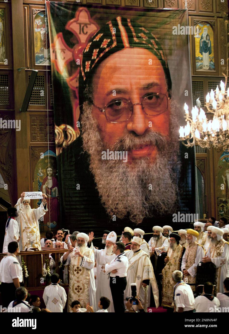 Acting Coptic Pope Pachomios, left, displays the name of the new Pope ...