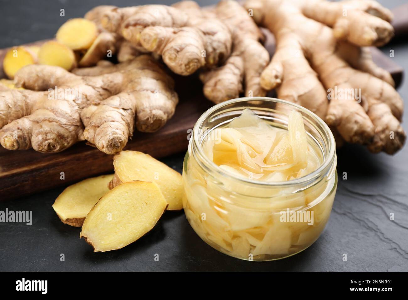 Spicy pickled ginger and root on black table Stock Photo - Alamy