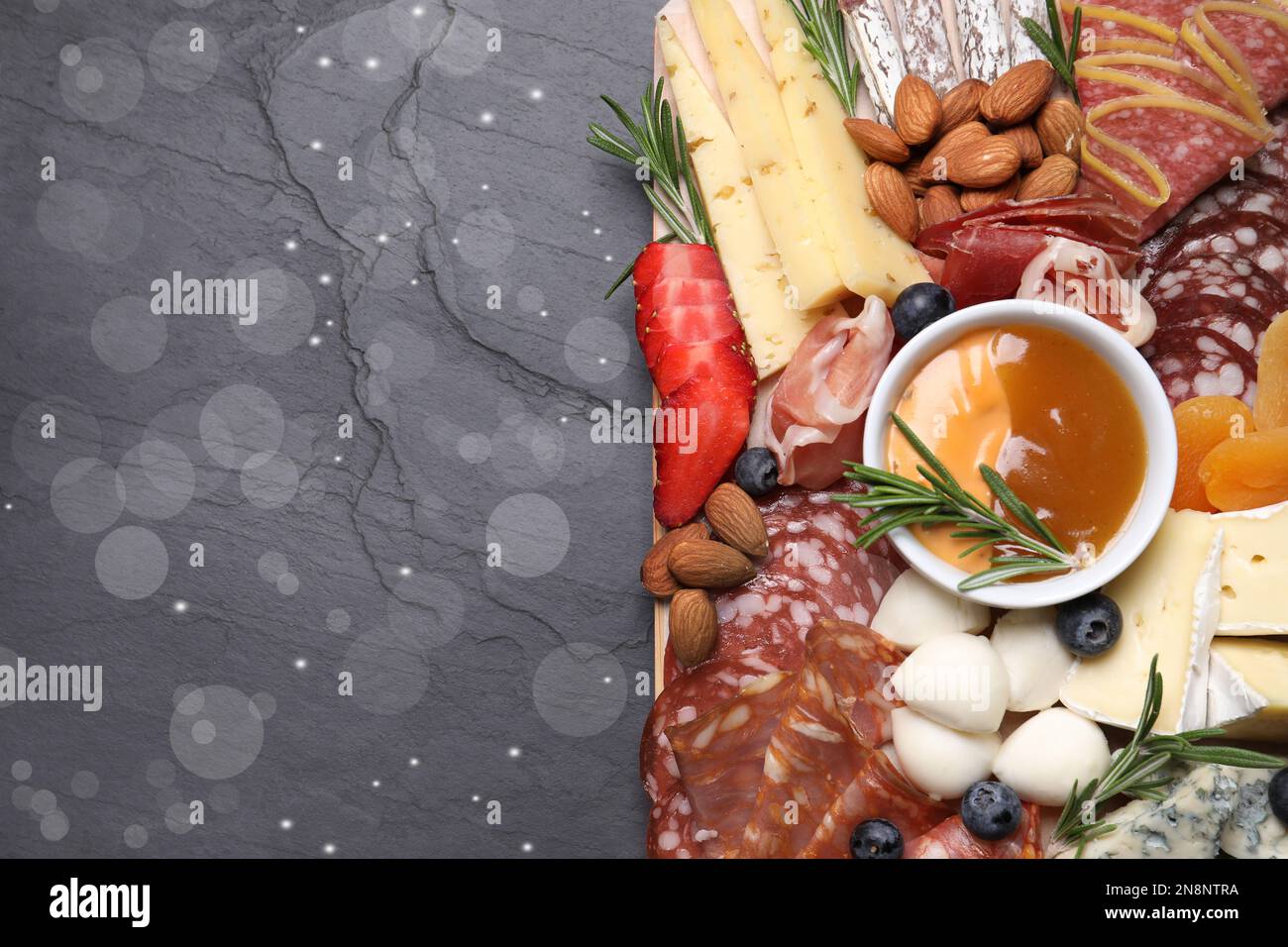 Different delicious snacks on black table, top view. Space for text ...