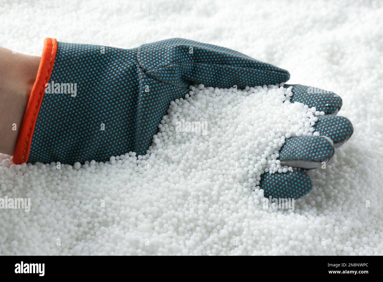 Farmer taking pellets of ammonium nitrate from pile, closeup. Mineral ...