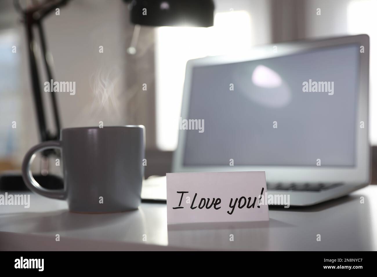 Note with handwritten text I Love You on workplace indoors. Romantic ...
