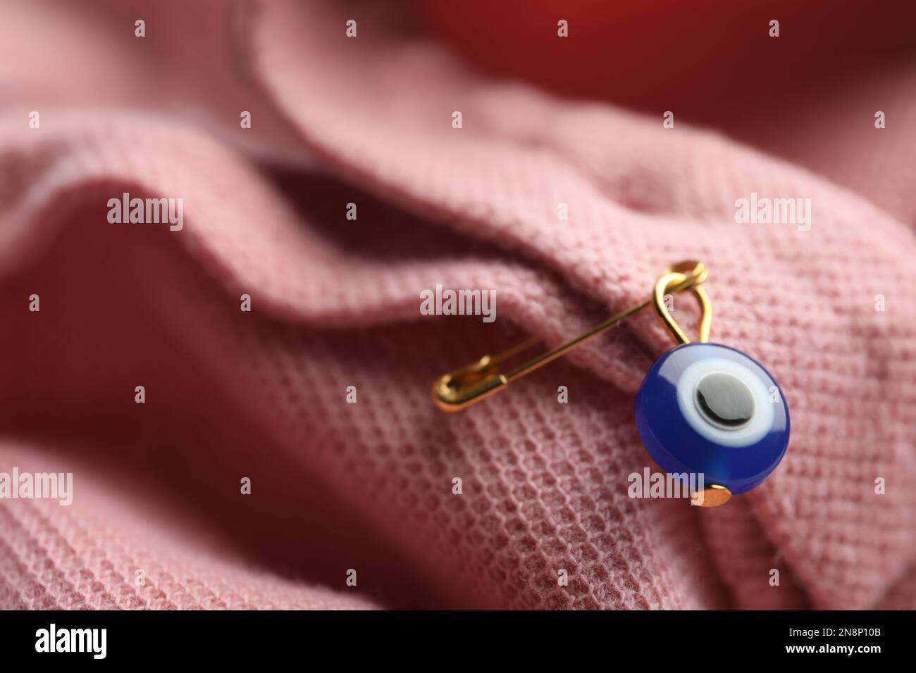 Evil eye safety pin on clothing, closeup Stock Photo - Alamy