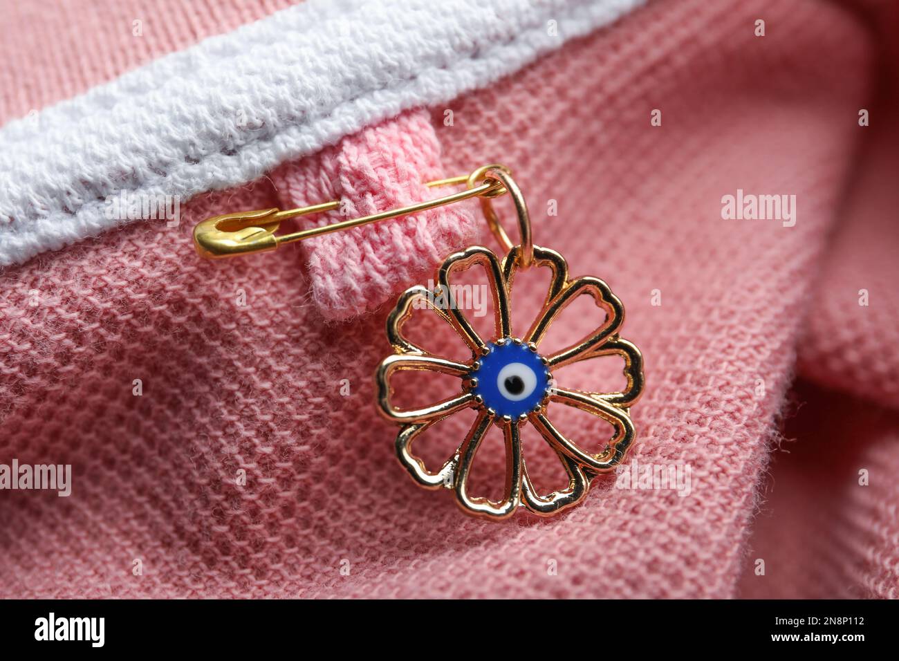 Evil eye safety pin on clothing, closeup Stock Photo - Alamy