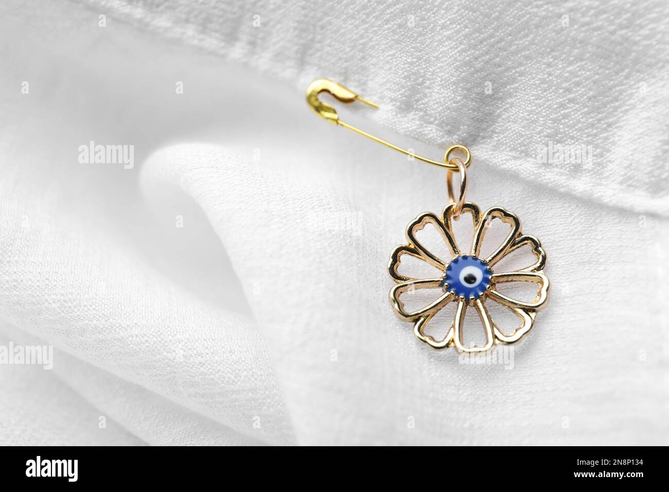 Evil eye safety pin on clothing, closeup Stock Photo - Alamy