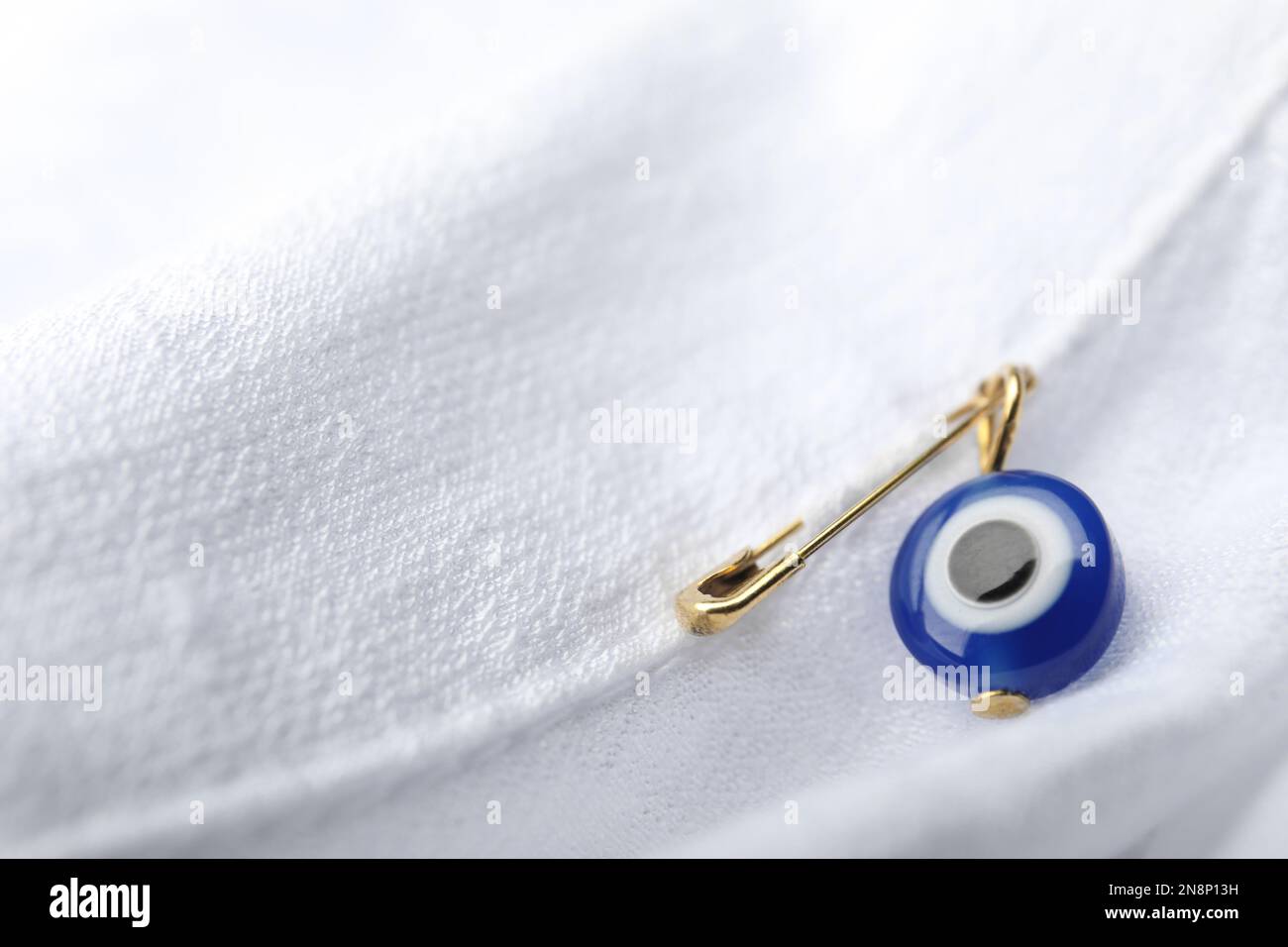 Evil eye safety pin on clothing, closeup Stock Photo - Alamy