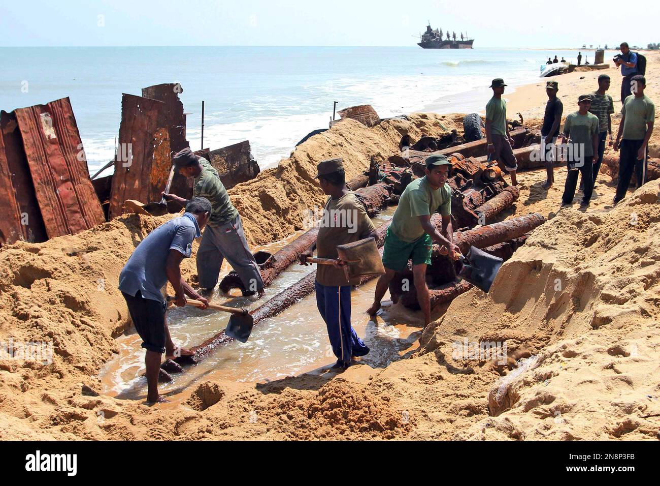 Sri Lanka Army soldiers recover weapons unearthed by recent storms in ...