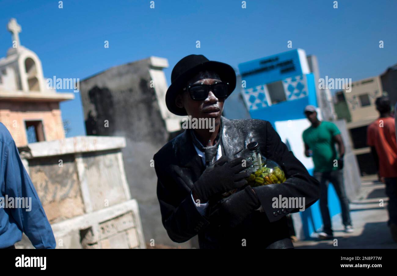 A Voodoo believer dressed as a Gede, or spirit, walks in the cemetery ...