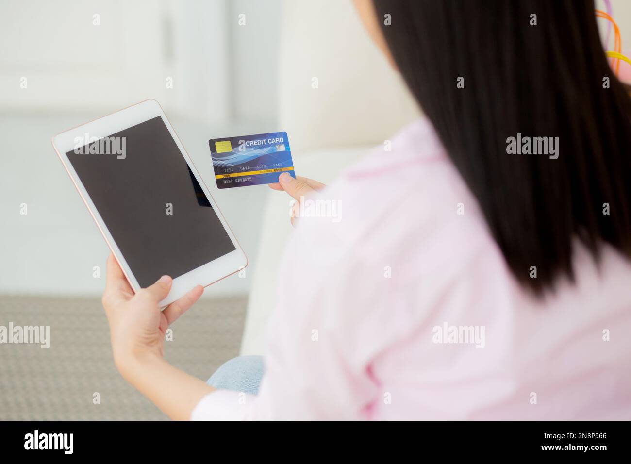 Young asian woman holding credit card shopping online with tablet ...