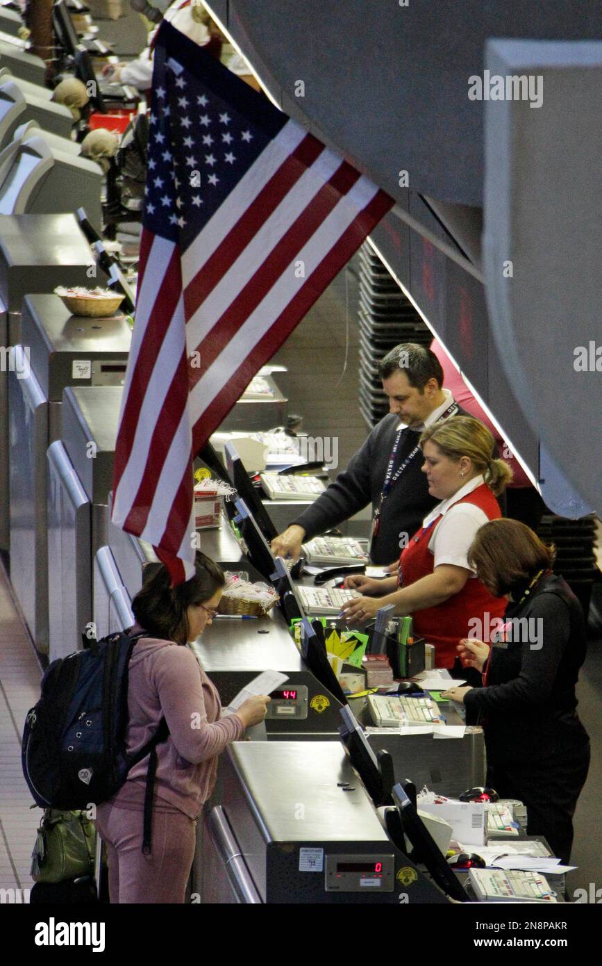 A passenger checks in for a flight at the Delta Airlines ticket counter ...