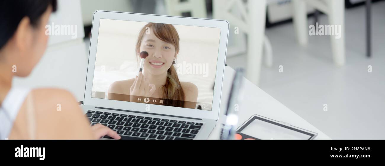 Beauty of young asian woman with learning makeup with brush on cheek on ...