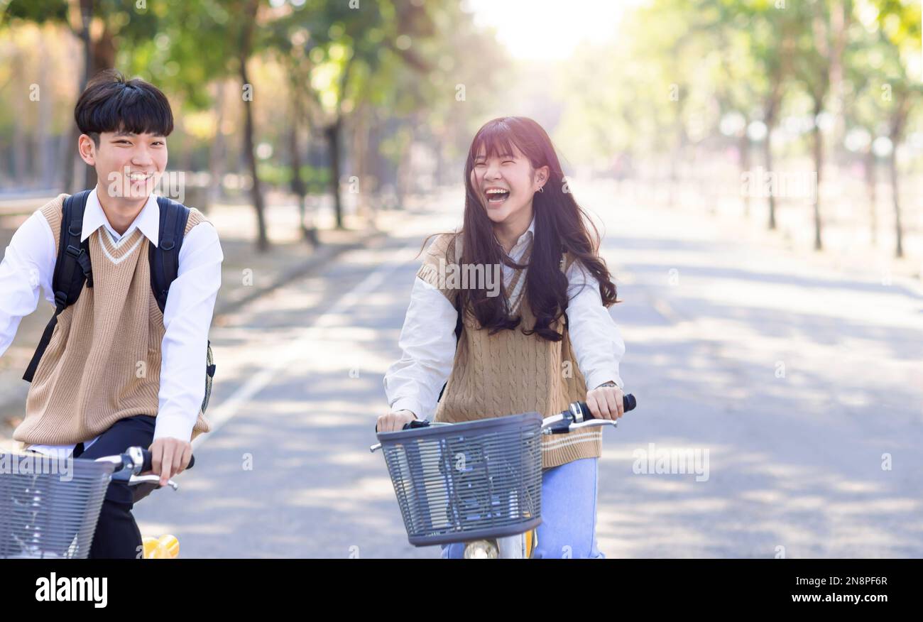 Happy teenager students riding bicycle at the school Stock Photo - Alamy