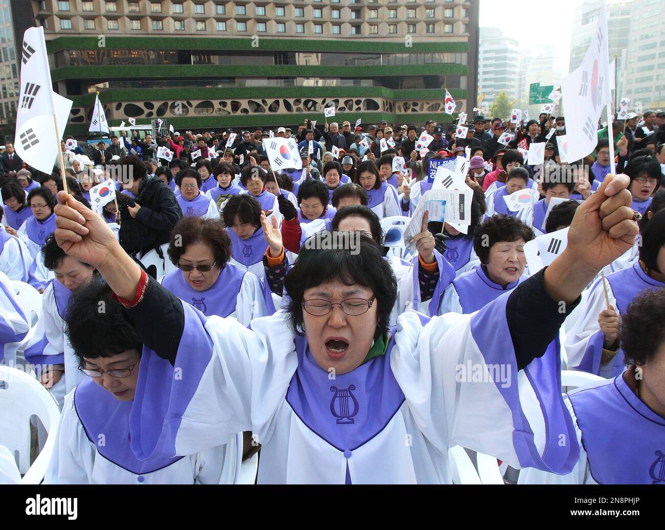 South Korean Christians with national flags pray during a rally against ...