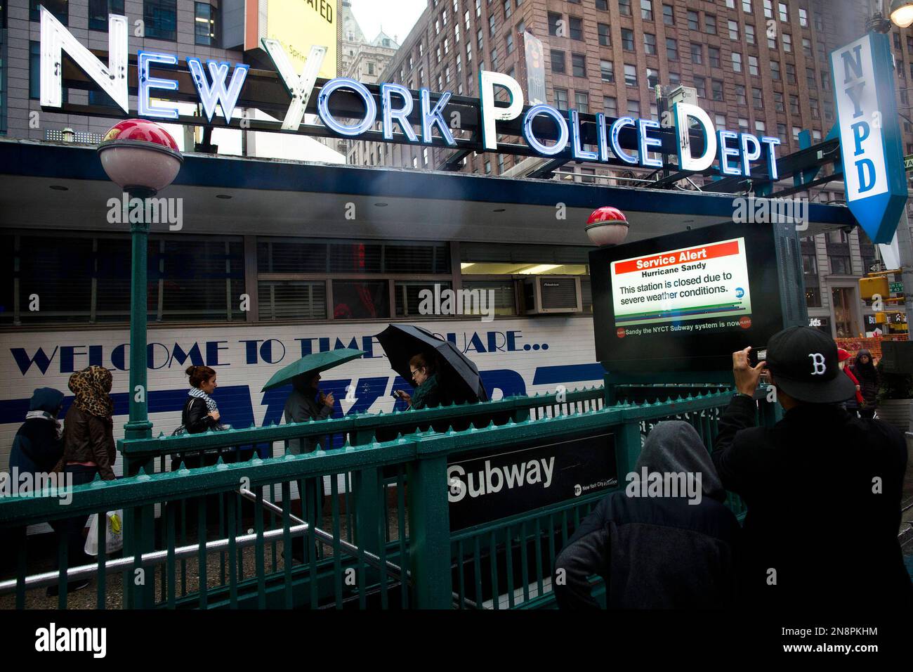 Pedestrians pass a New York Police Department station beside a closed ...