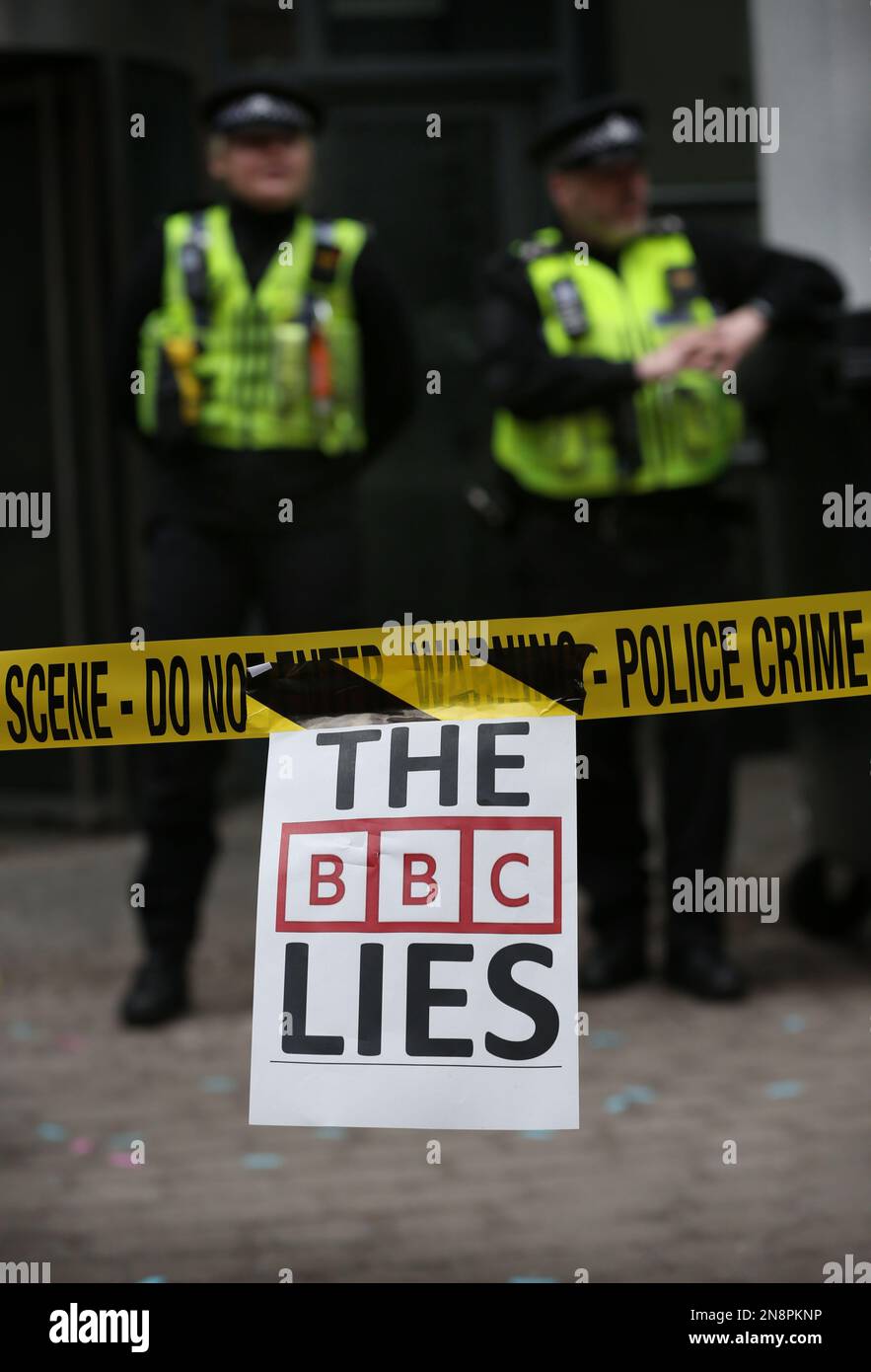 Protesters stick 'The BBC Lies' signs on police tape as police prevent ...