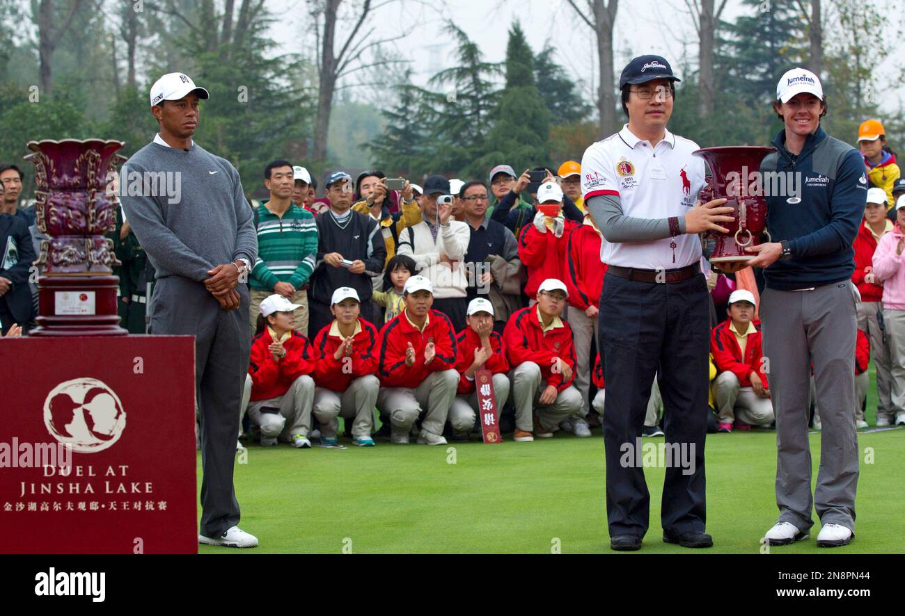 Tiger Woods, left, watches, while Rory McIlroy, right, gets his trophy ...