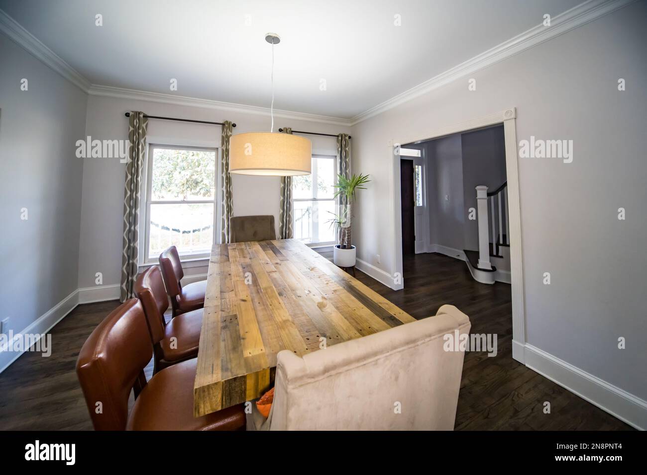 A modern dining room with a stained with a stained wood table, bench ...