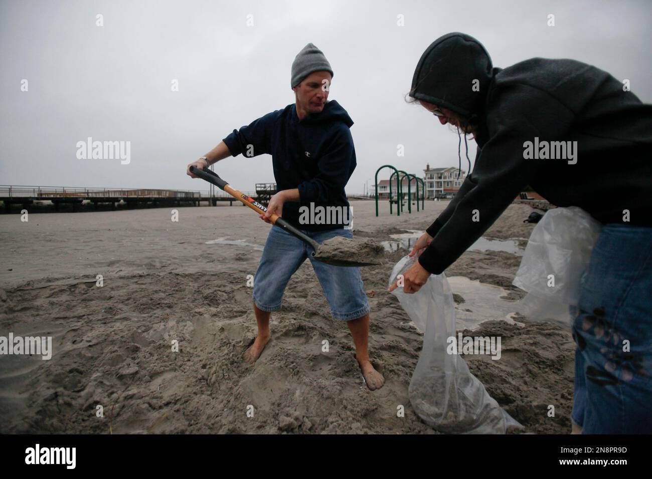 Terry Junker, left, and Nancy Lisowski fill sandbags at the beach in ...