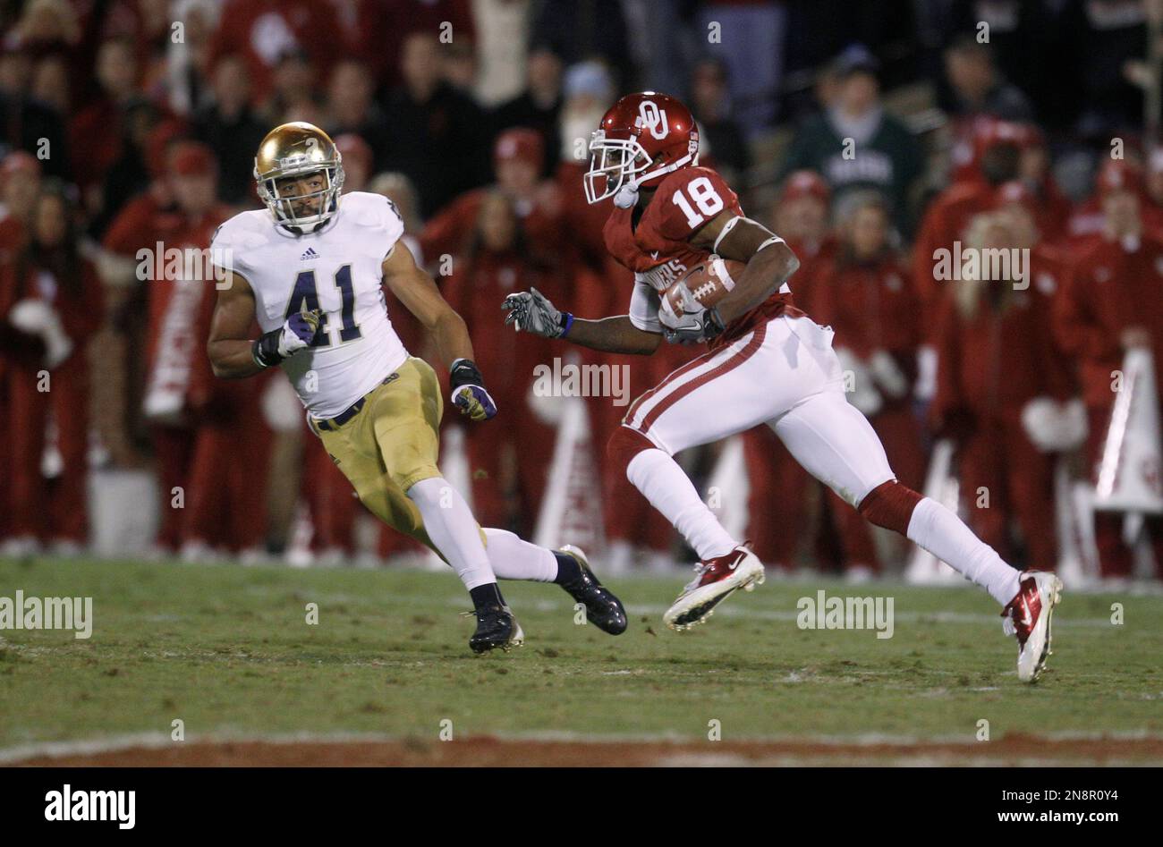 Oklahoma Jalen Saunders (18) carries past Notre Dame safety Matthias ...