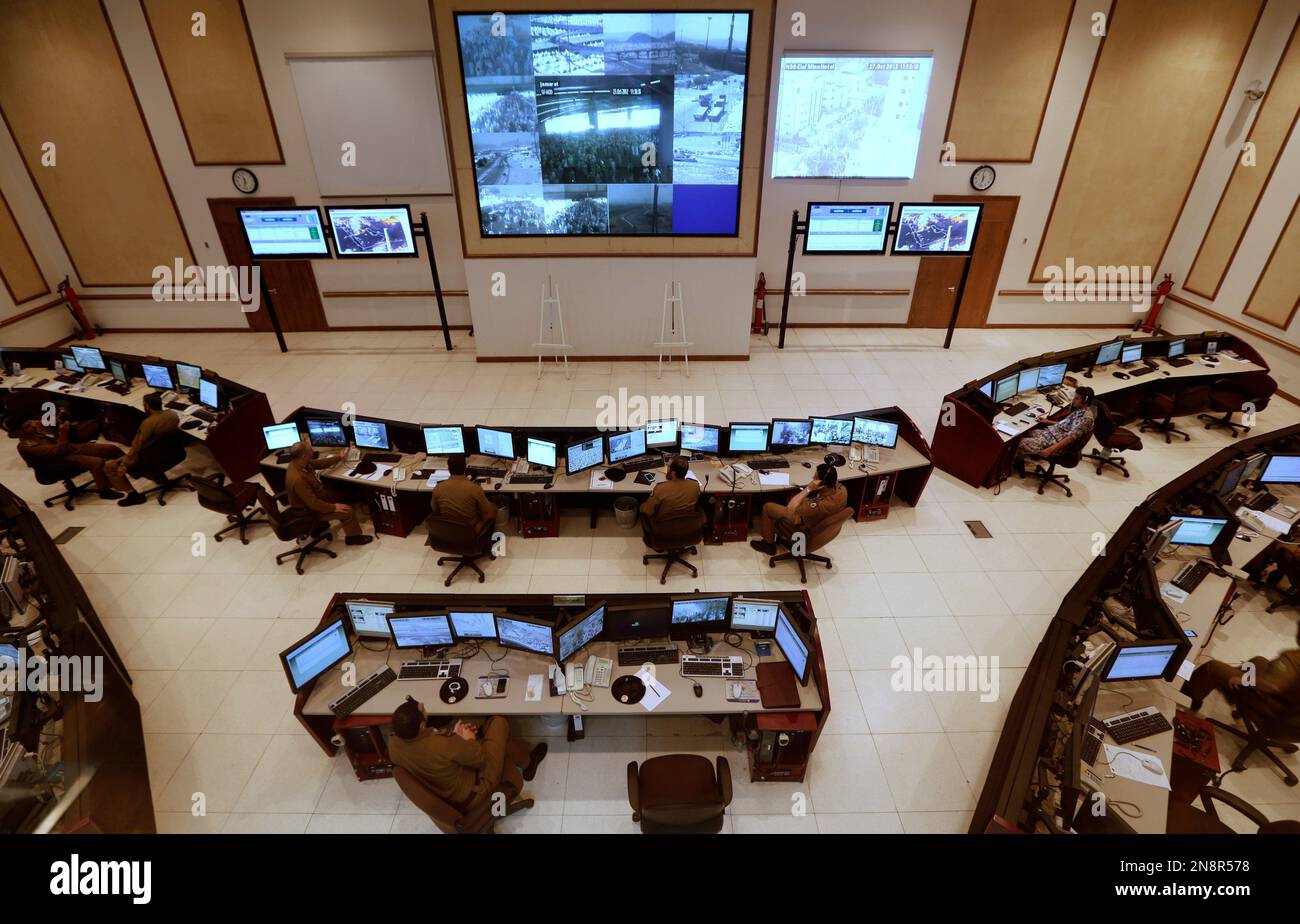 Saudi police officers monitor screens connected to cameras set up to ...