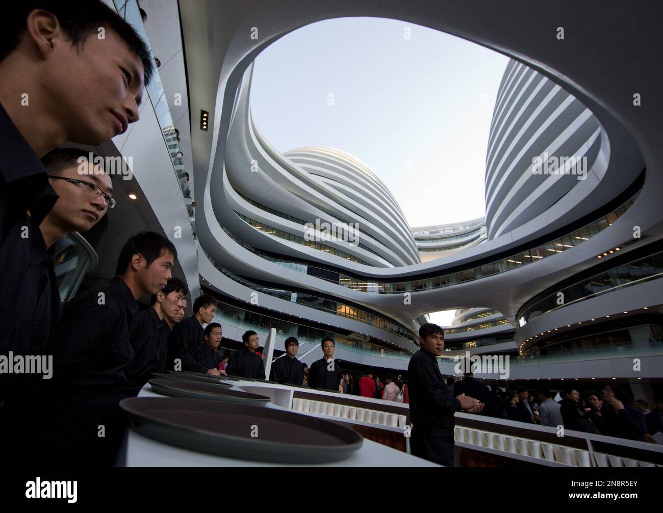 Waiters wait to serve the visitors at the newly opened Galaxy Soho ...