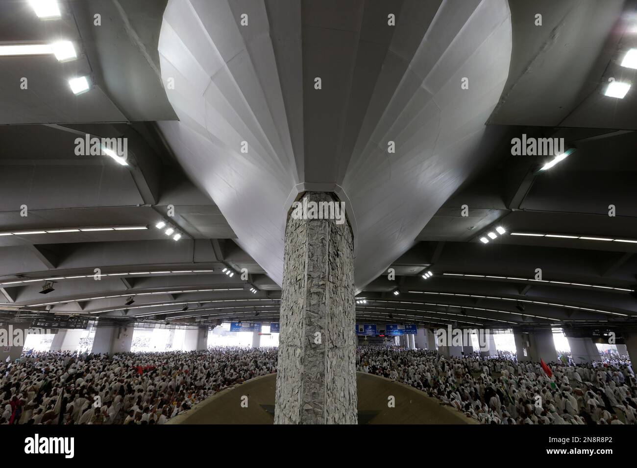 Muslim pilgrims cast stones at a pillar, symbolizing the stoning of ...