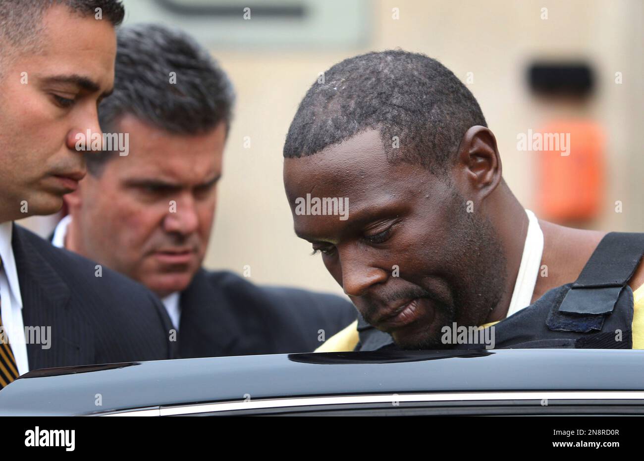 Darrell Fuller is escorted into a waiting car at a police station in ...