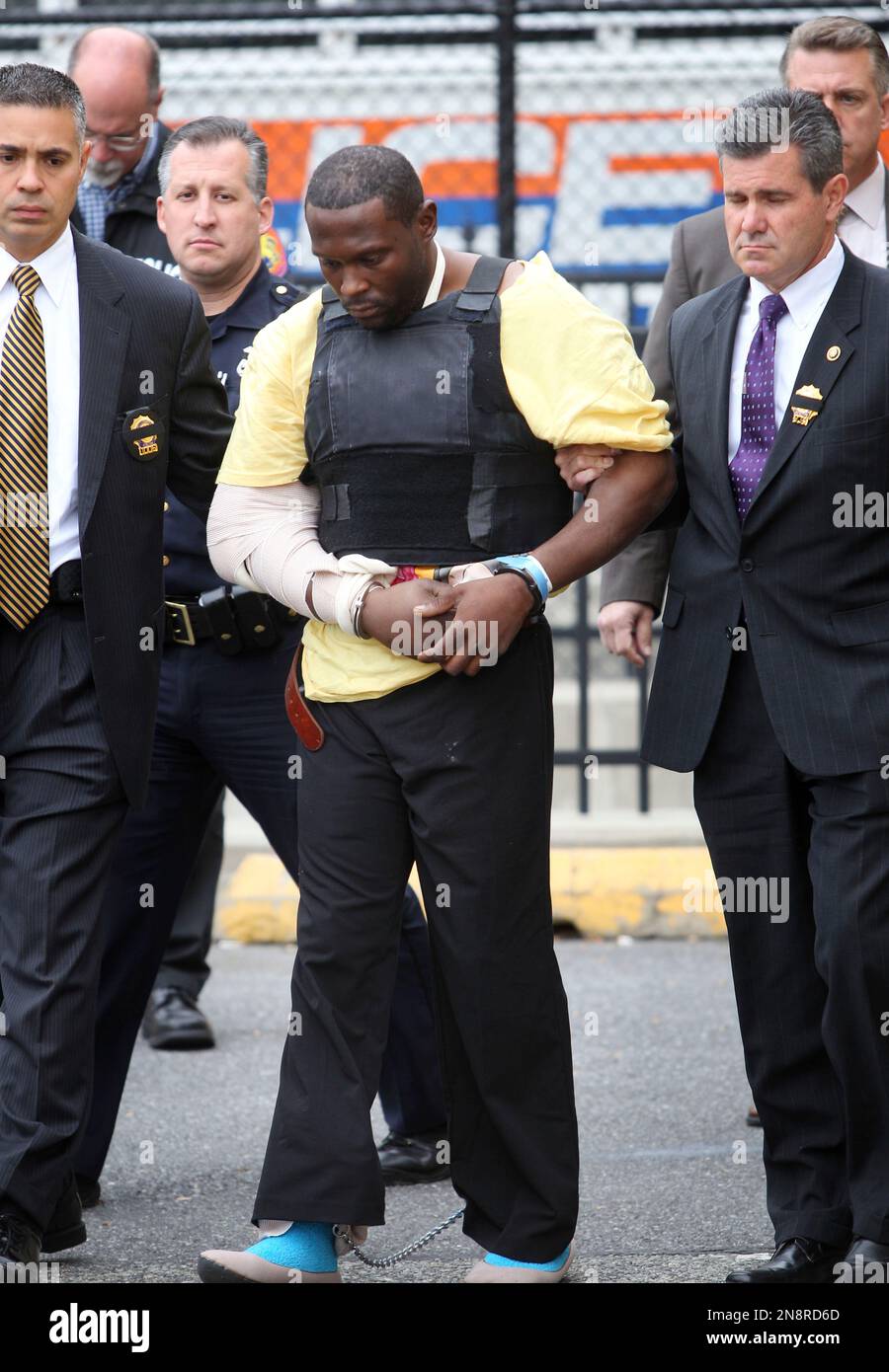 Darrell Fuller is escorted out of a police station in Mineola, N.Y ...