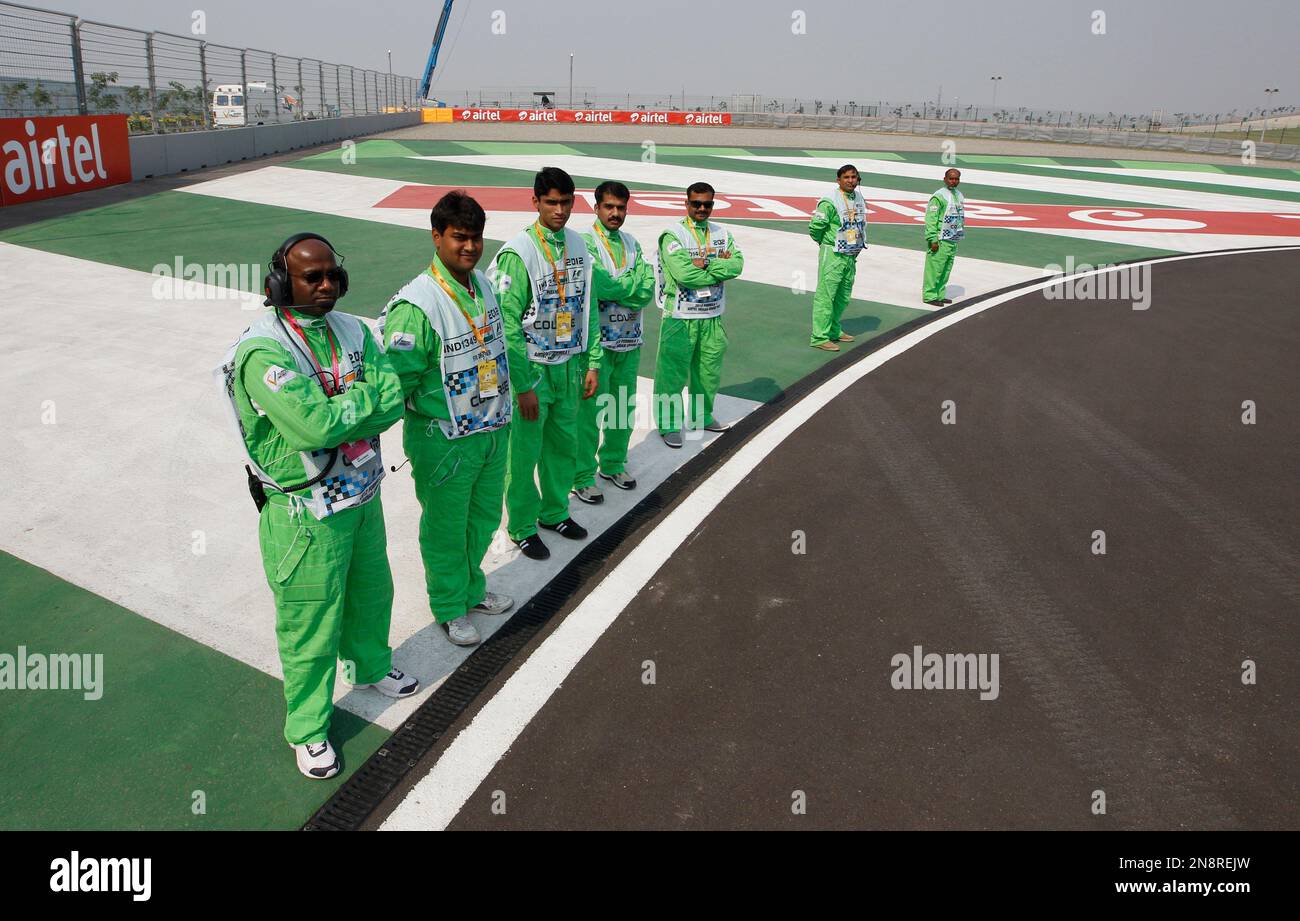 Track marshals stand at turn one as final preparations are made for the ...