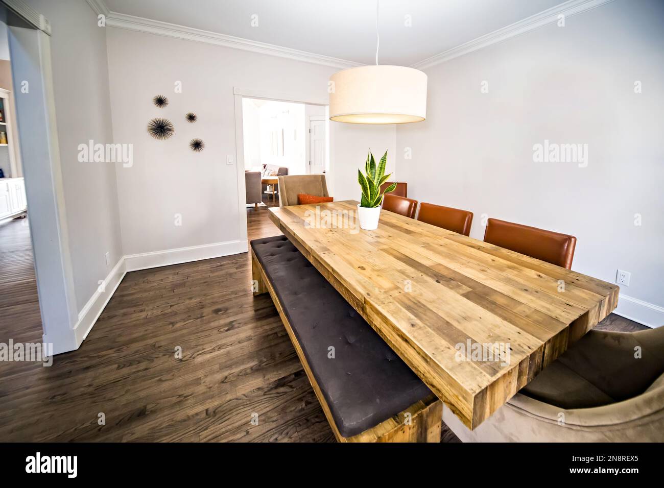 A modern dining room with a stained with a stained wood table, bench ...