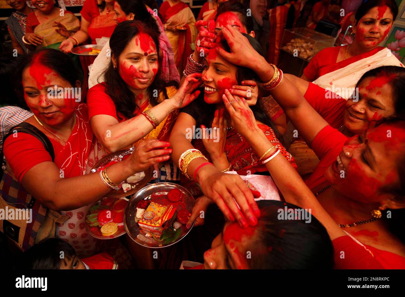 Hindu women apply vermillion powder on each other during Durga Puja ...