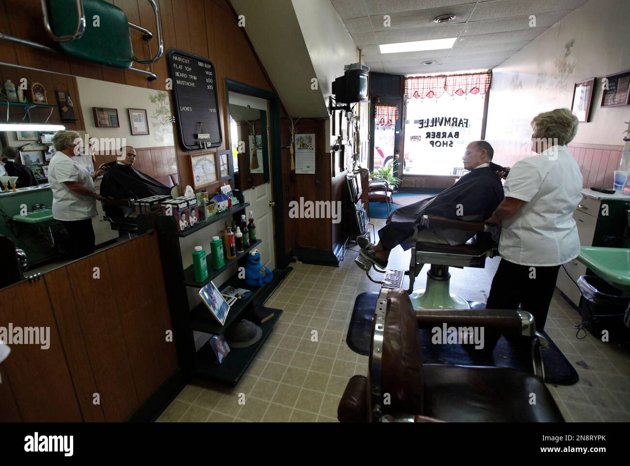 Robin Davis, owner of the 100-year-old Farmville Barber Shop gives ...