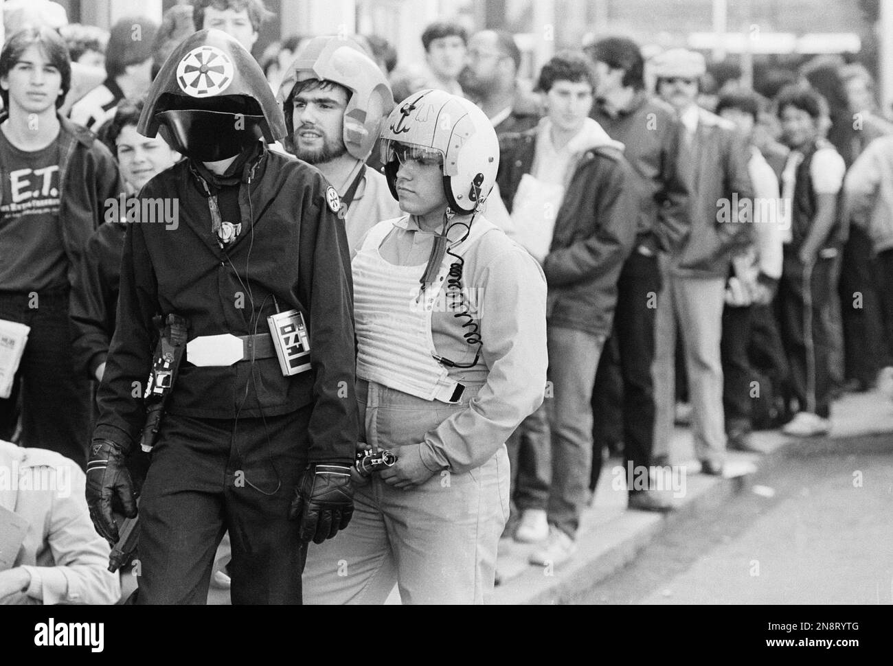 Three costumed fans of the "Star Wars" movie trilogy stands in a line ...