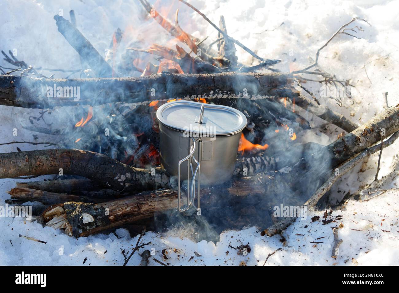 Cantine cup heating in an outdoor campfire in the winter. Quebec,Canada ...